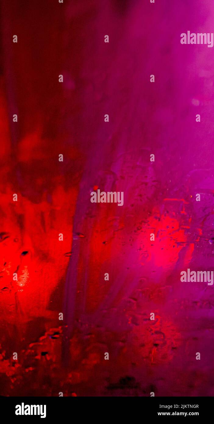 A vertical abstract neon texture with pink and purple oil paints on the ...