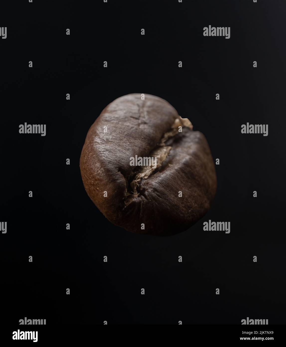 A floating coffee bean on a black gradient background Stock Photo - Alamy