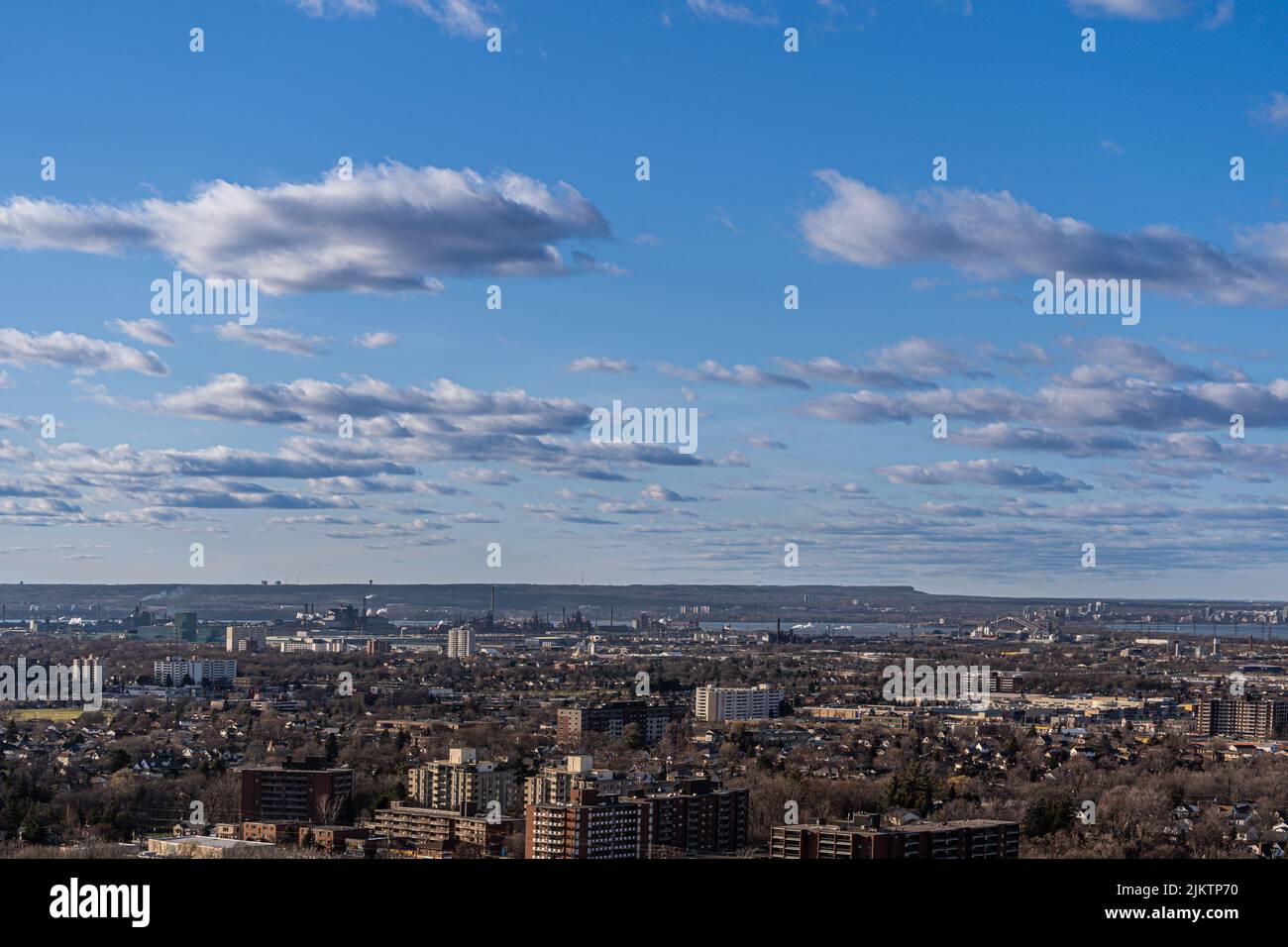 An aerial view of the cityscape of Hamilton city under a cloudy sky in ...