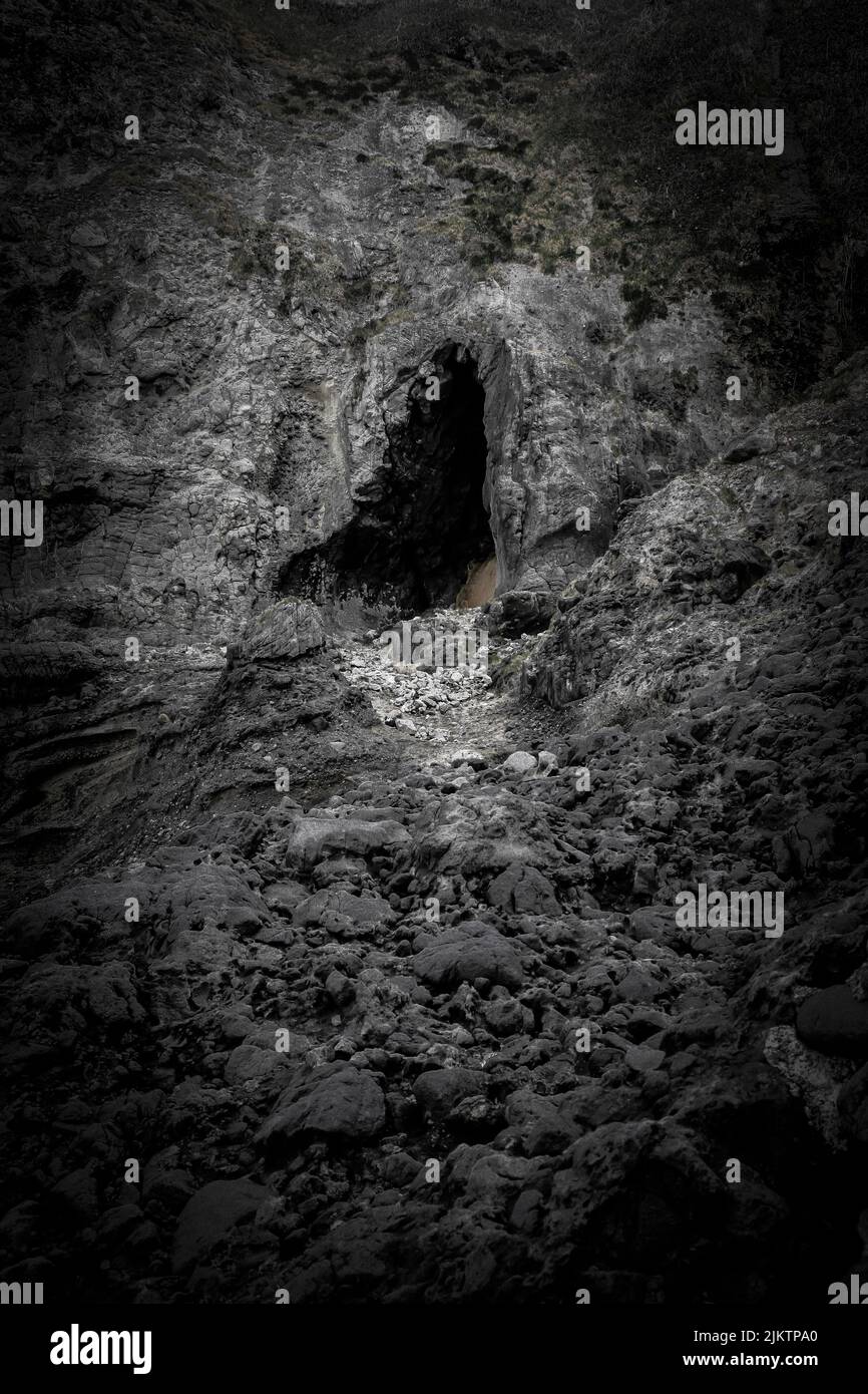 A vertical grayscale shot of the cave on the cliff Stock Photo - Alamy