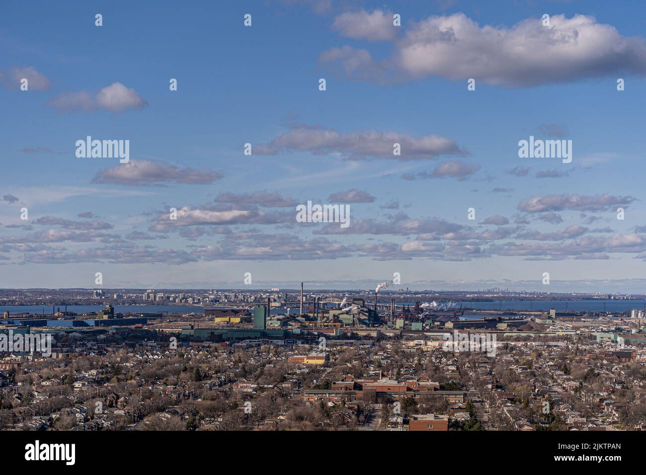 An aerial view of the cityscape of Hamilton city under a cloudy sky in ...