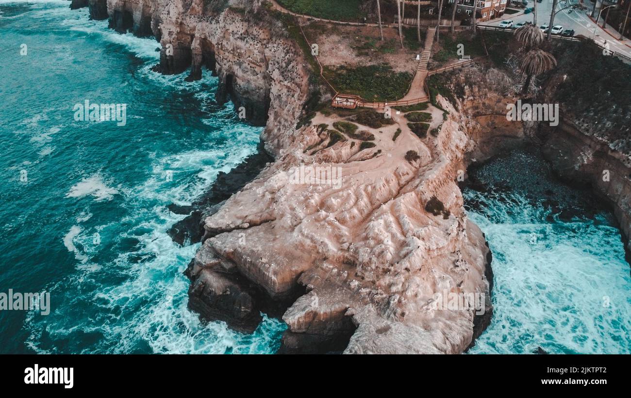 A bird's eye view of a cliff near the blue water of a sea Stock Photo ...