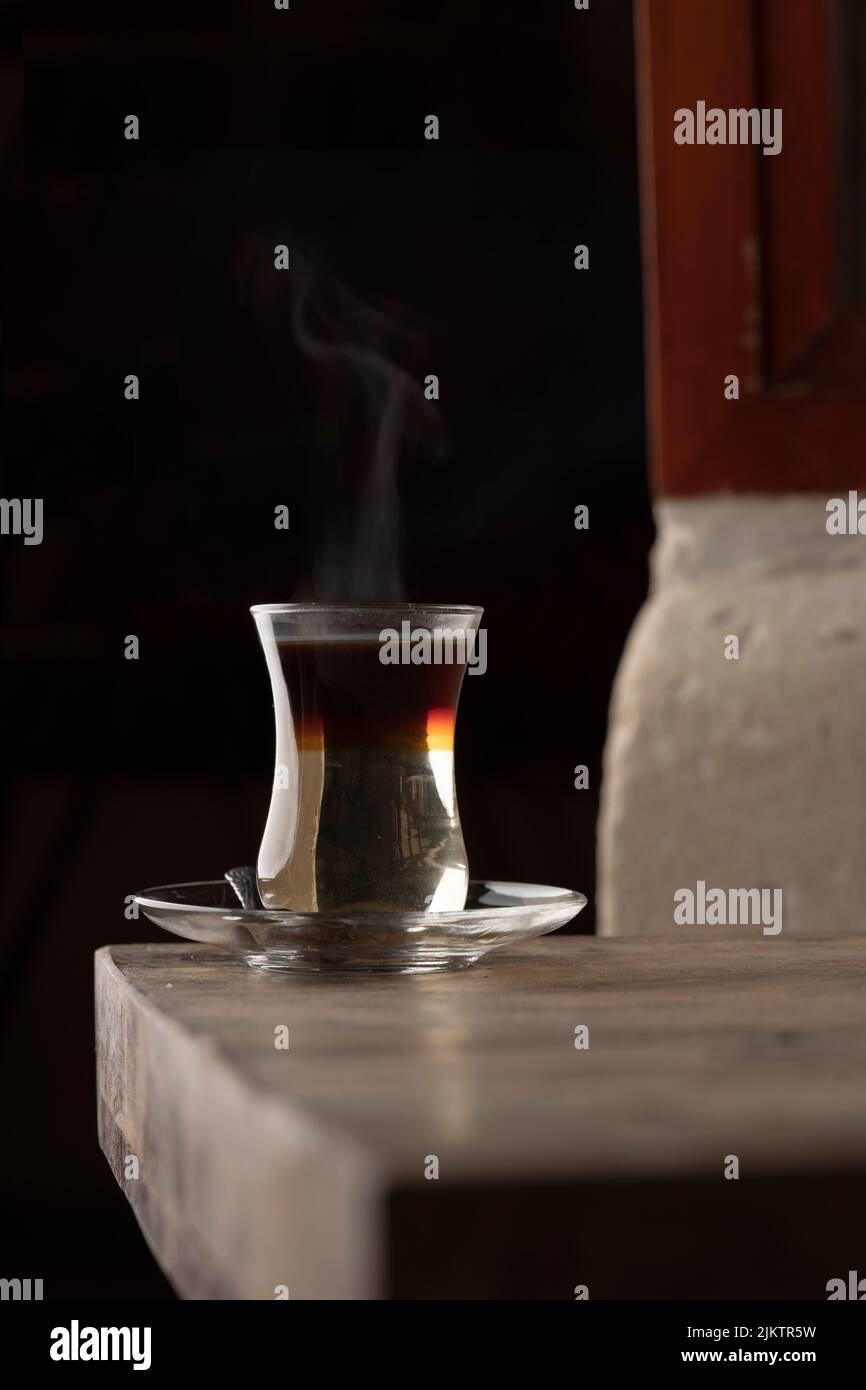 A vertical closeup of a Turkish tea with a flame on the stone table ...