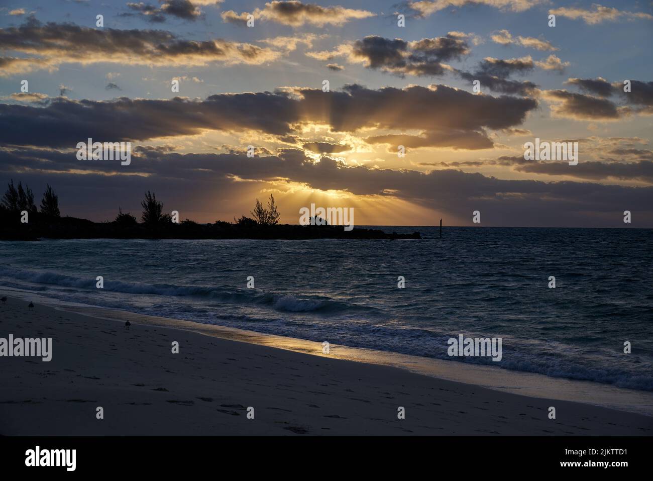 A scenic shot of sun rays shining through the clouds at sunset at the ...