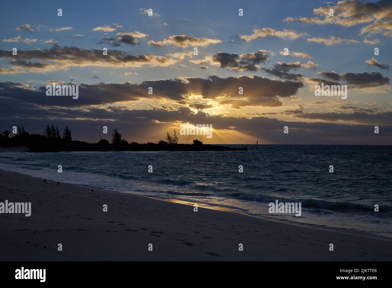 A scenic shot of sun rays shining through the clouds at sunset at the ...