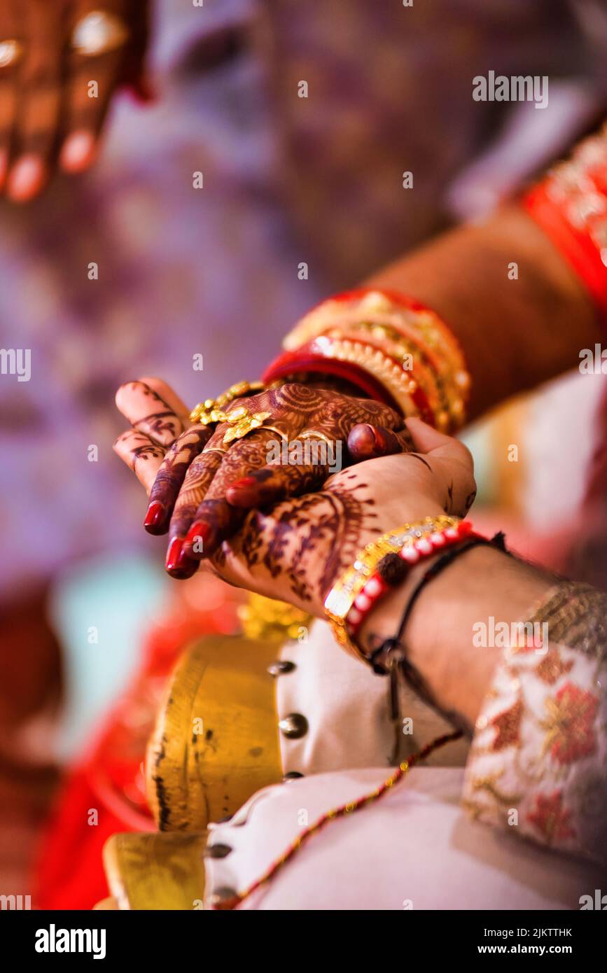 A Closeup of hands with henna tattoos during an Indian traditional ...