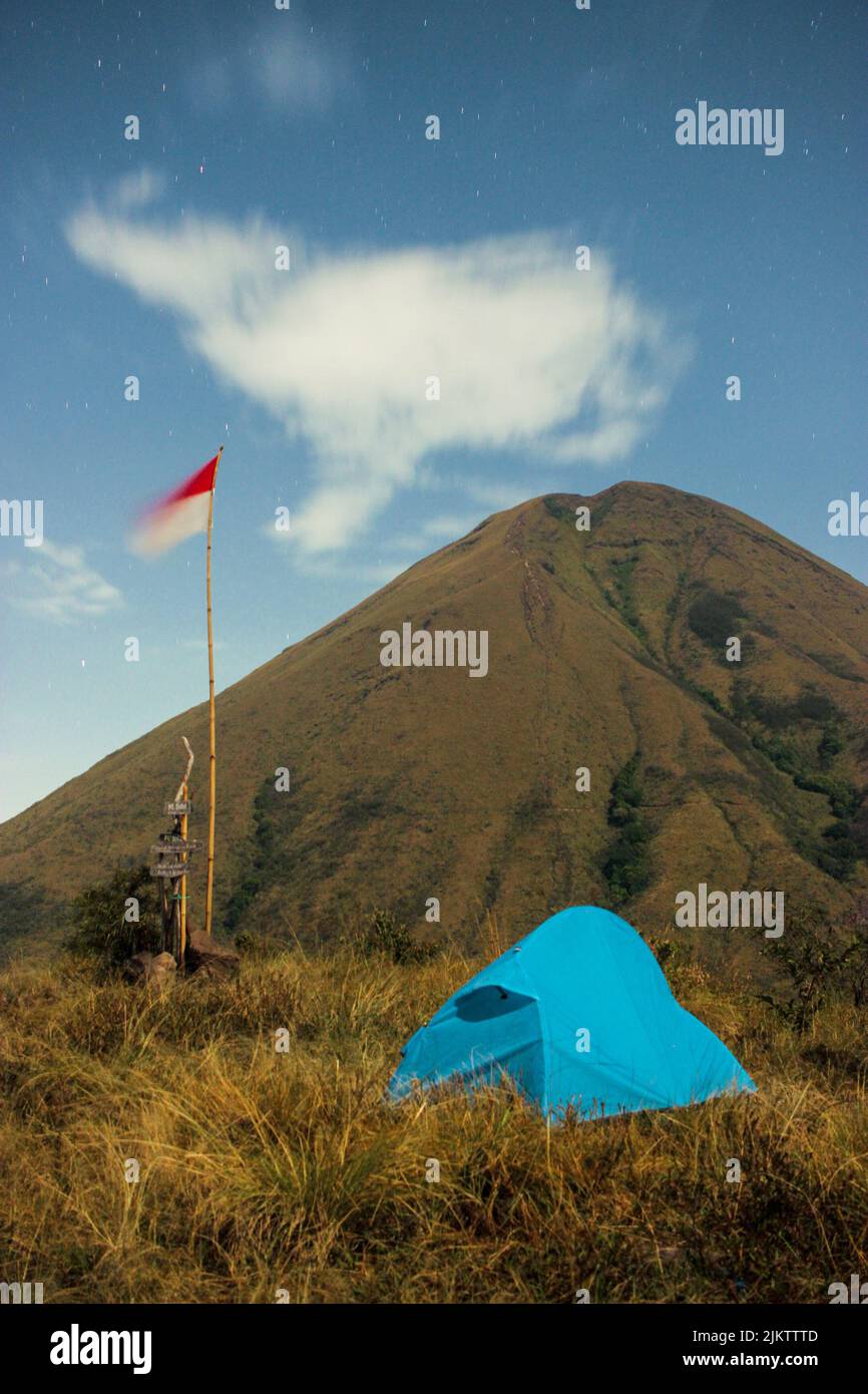 A Blue tent on the peak of hills with a view of mountains and a white ...