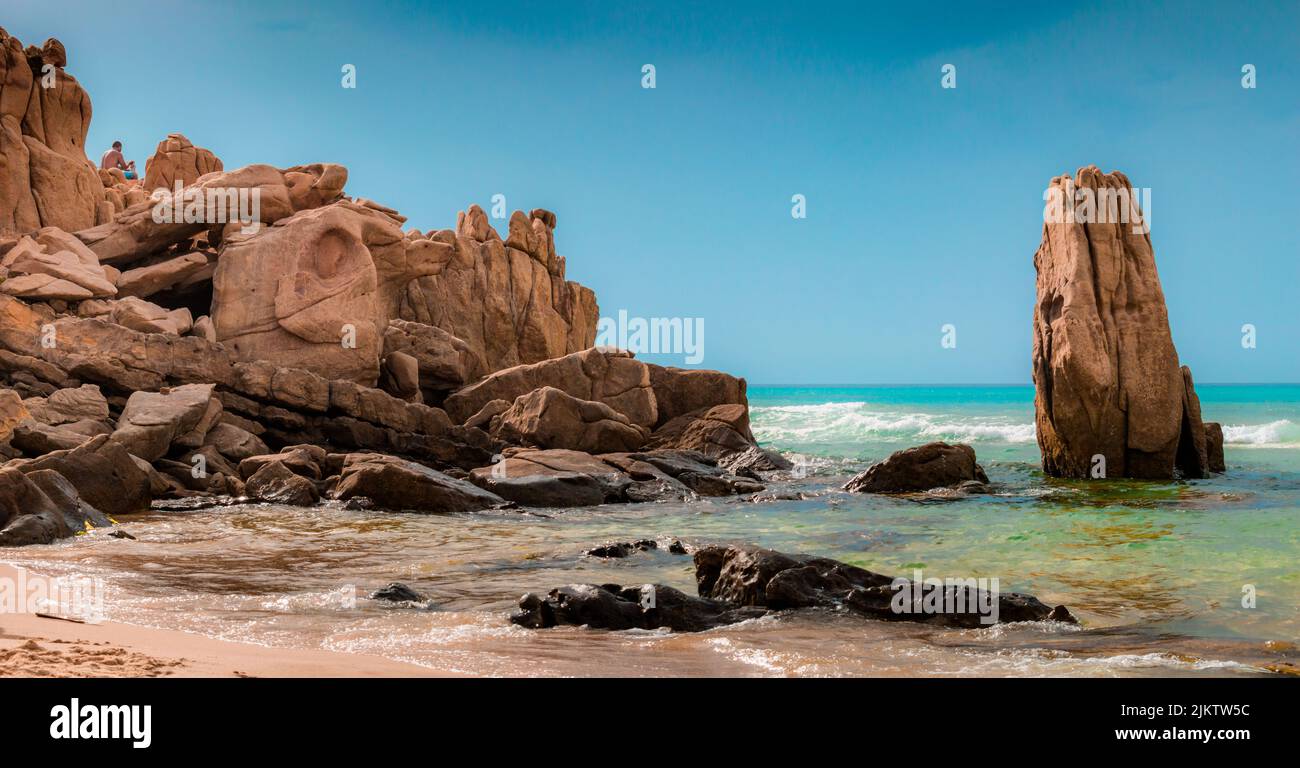 A stack of huge rocks on the sandy shore of blue sea Stock Photo - Alamy