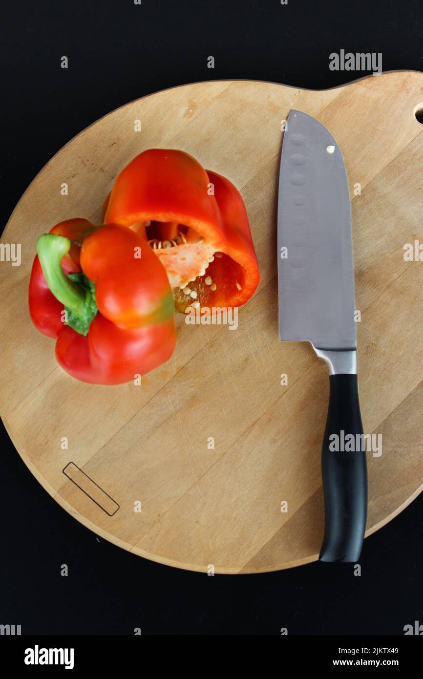 Knife cut the red pepper in kitchen on wooden board Stock Photo - Alamy