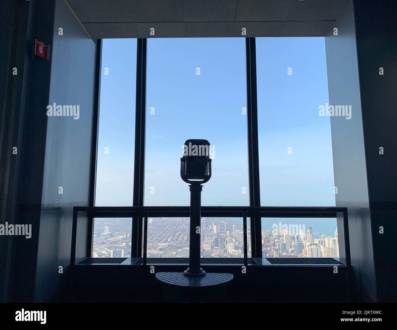 A closeup of the binocular telescope in front of windows at the ...