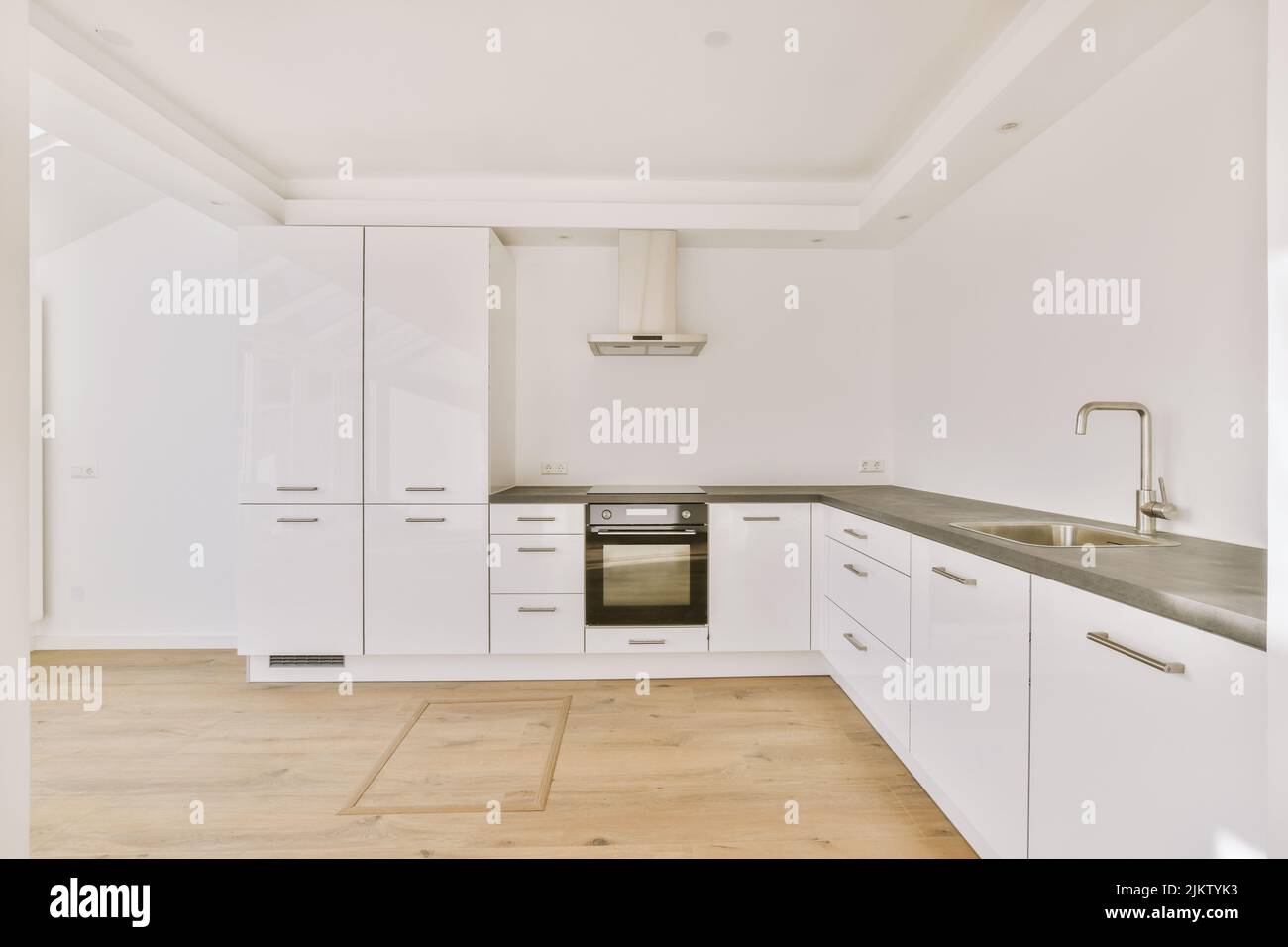 Interior of empty white kitchen with windows and wooden parquet floor ...