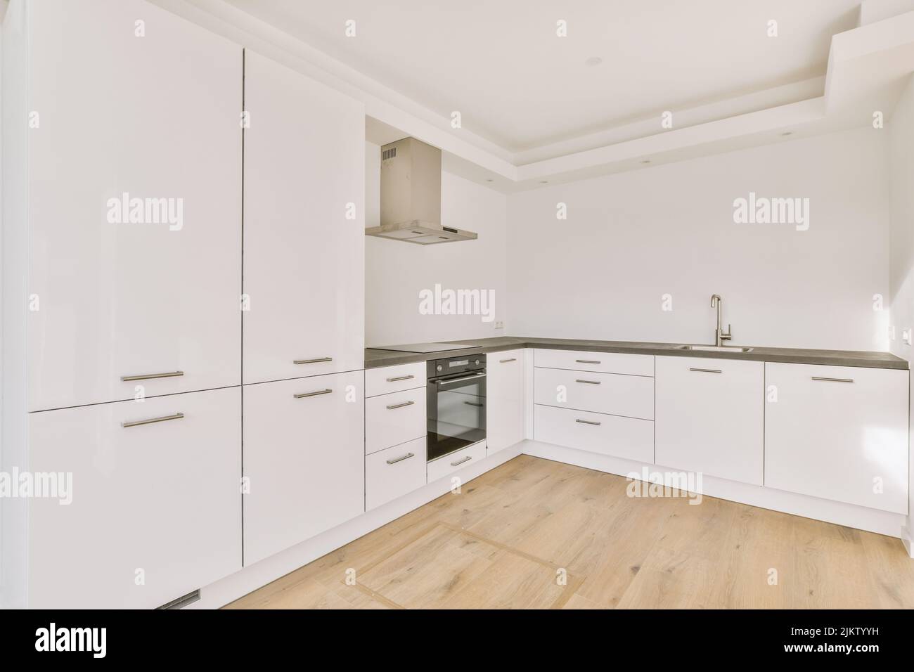 Interior of empty white kitchen with windows and wooden parquet floor ...