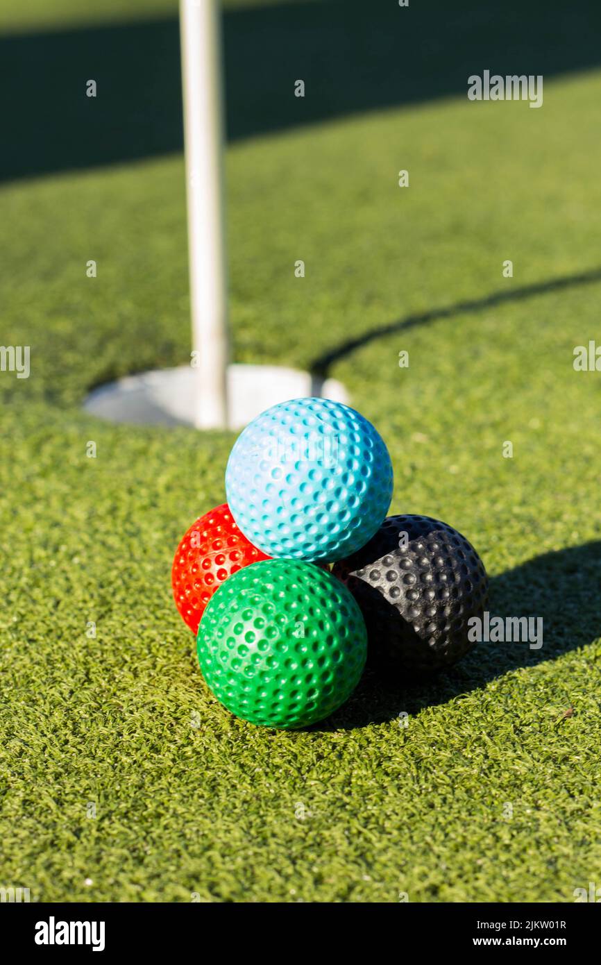 A vertical shot of colorful four golf balls in a green golf field Stock ...