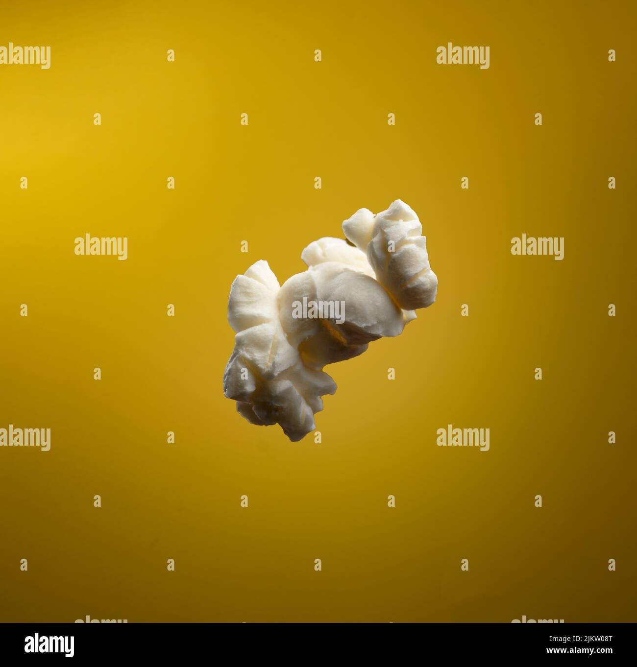 A single popcorn isolated on a yellow background Stock Photo - Alamy
