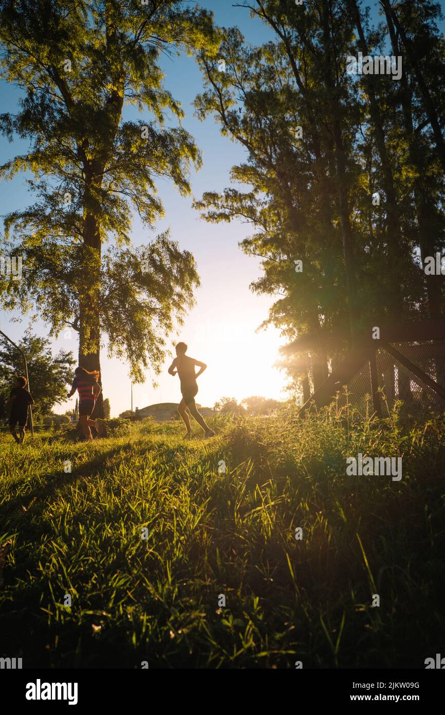 A vertical shot of children running in the woods Stock Photo - Alamy