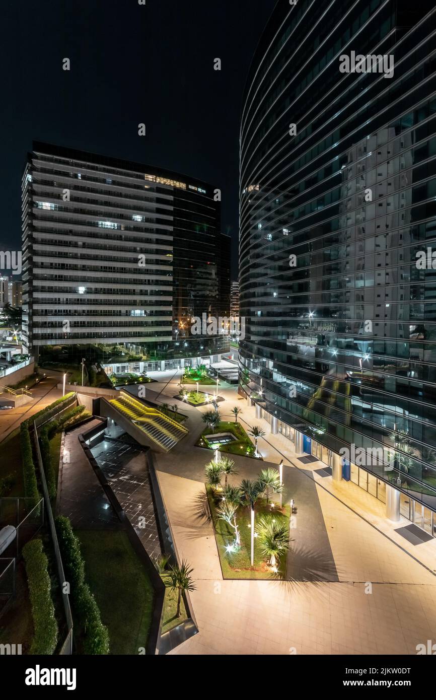 A vertical shot of the modern glass buildings at night in the city of ...