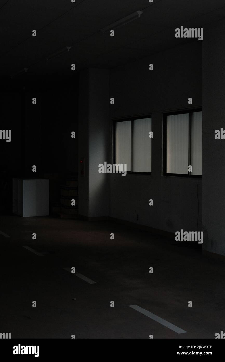 A dark empty store with grunge white walls with turned off lamps and ...