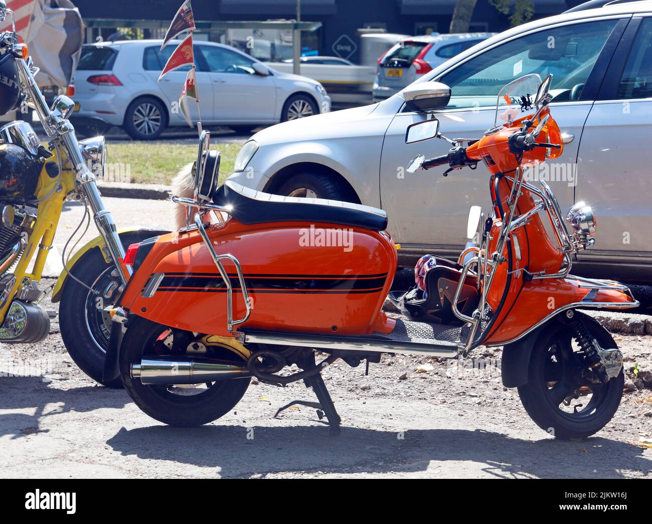 Well maintained shiny, metallic orange classic scooter. Summer 2022 ...