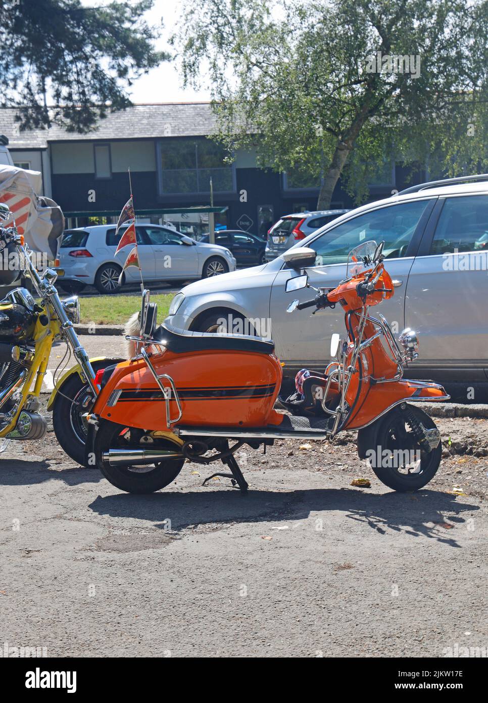 Well maintained shiny, metallic orange classic scooter. Summer 2022 ...
