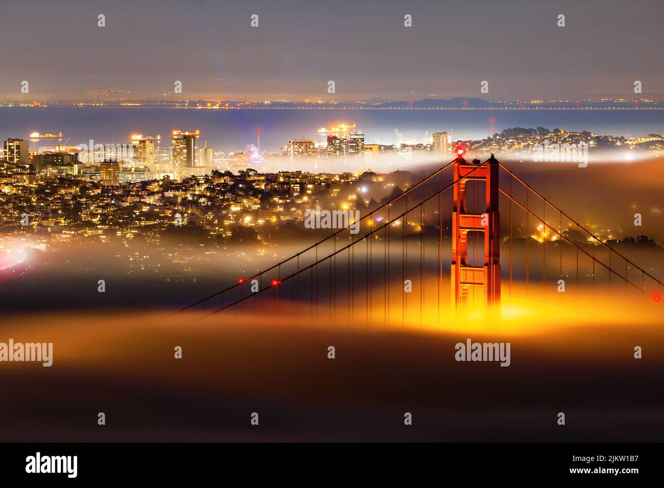 An incredible fog over Golden Gate Bridge at night in San Francisco ...