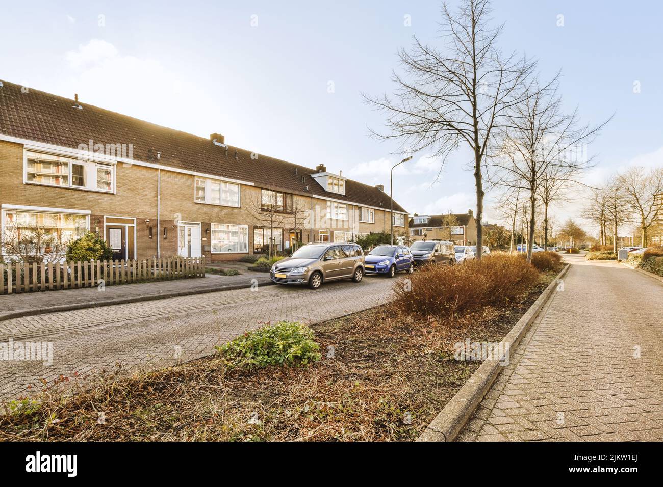 The front view of a brick building with signs, cars, pavement and ...
