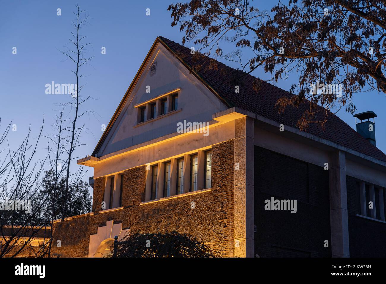 An exterior of a countryside modern house near the trees at evening ...