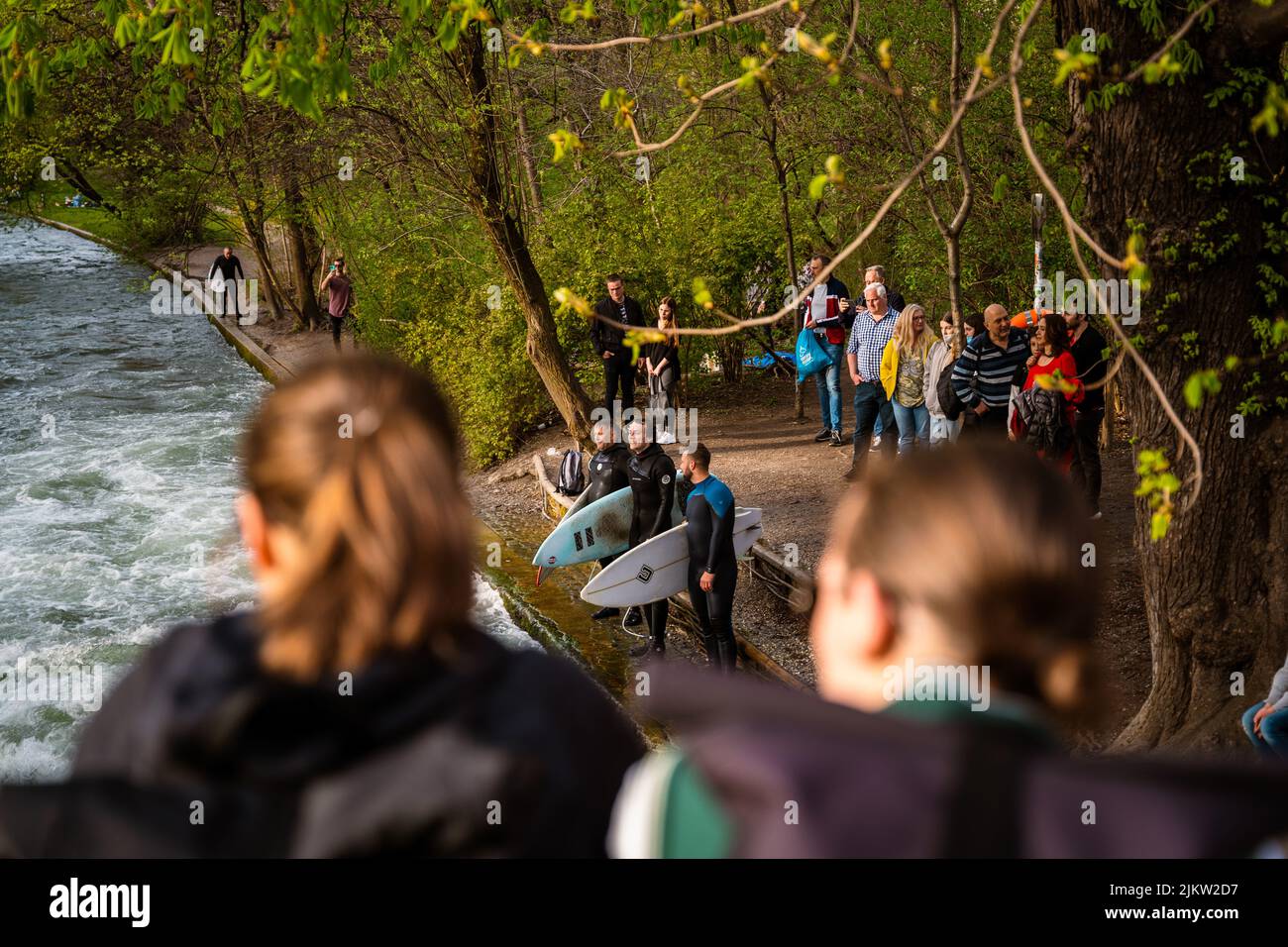 Surfers in Munich at the Eisbach river waiting to jump into the water ...