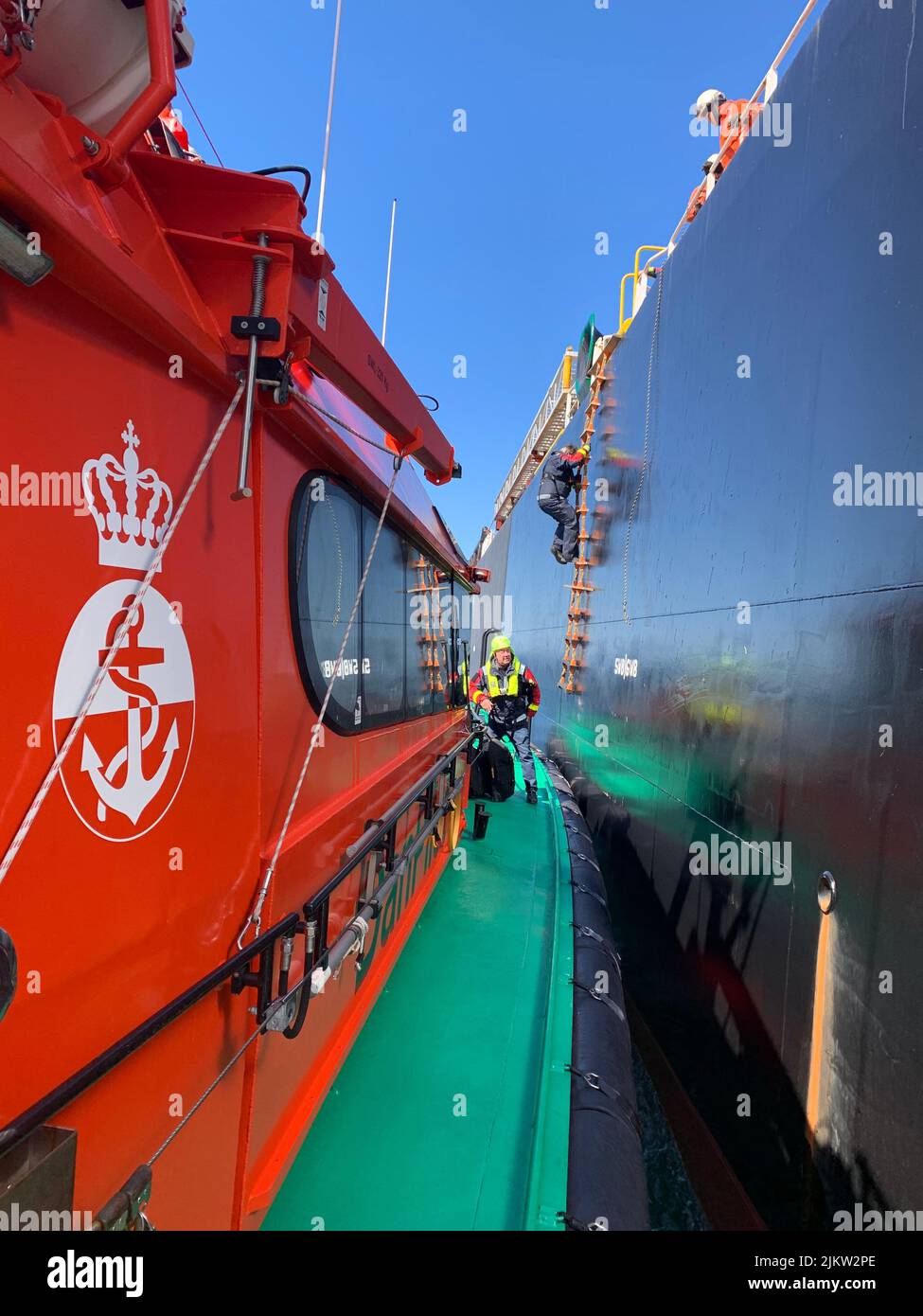 A pilot boat approaching to a big vessel in the sea Stock Photo - Alamy