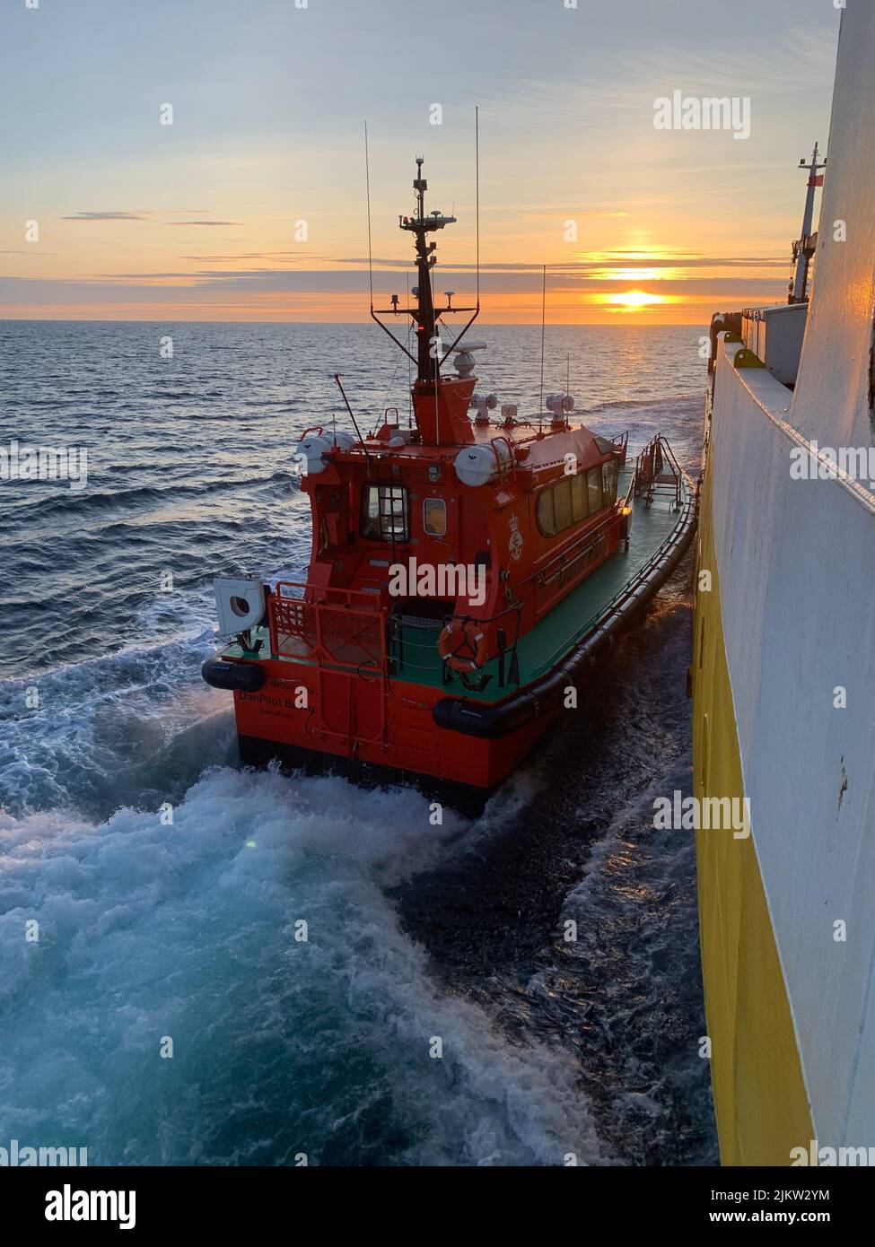 A pilot boat approaching to a big vessel in the sea Stock Photo - Alamy