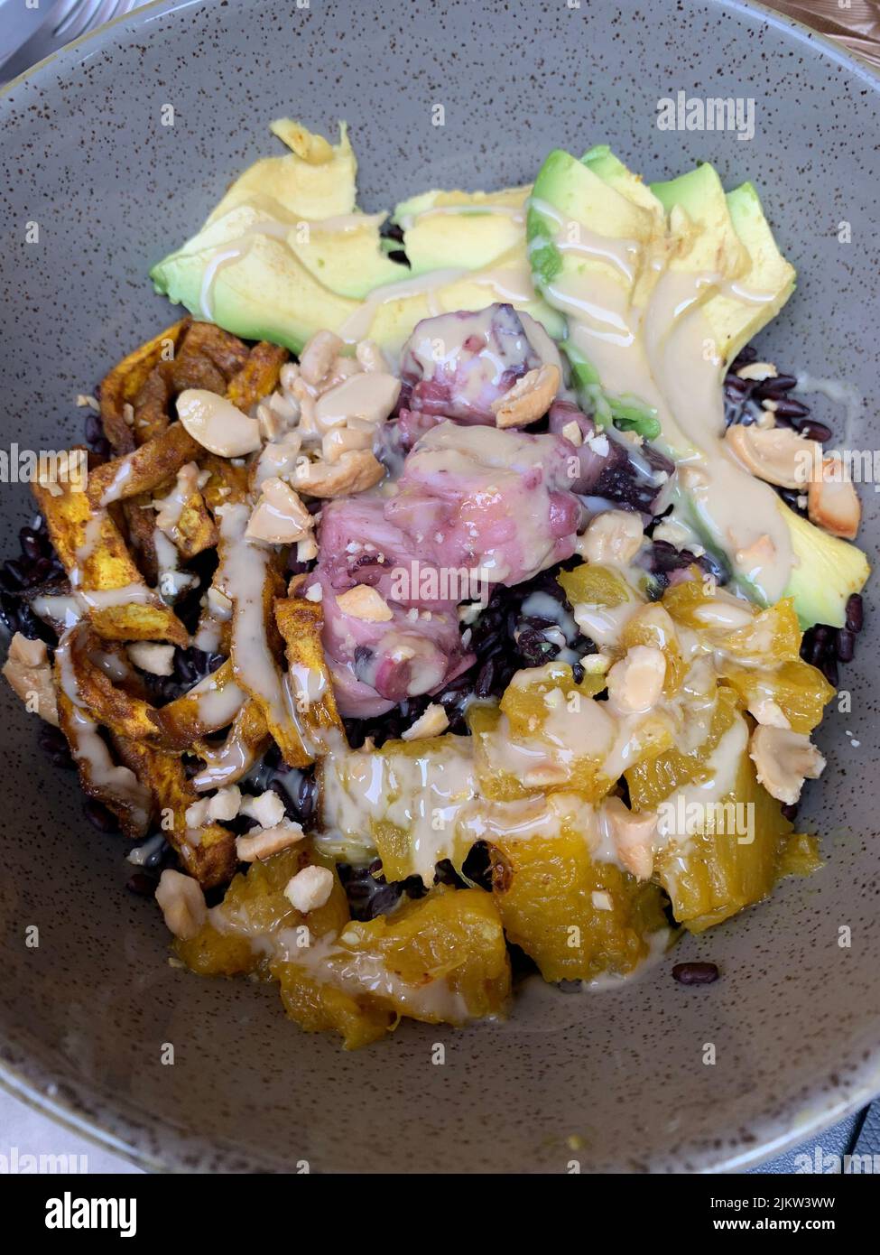 A vertical shot of a delicious Hawaiian poke bowl with octopus, avocado ...