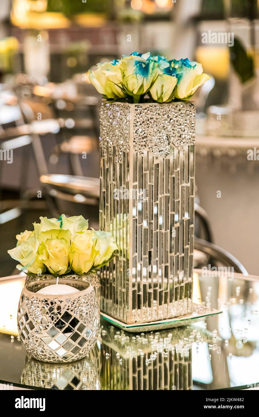 A beautiful glass flower vases with decorations on mirror table with ...