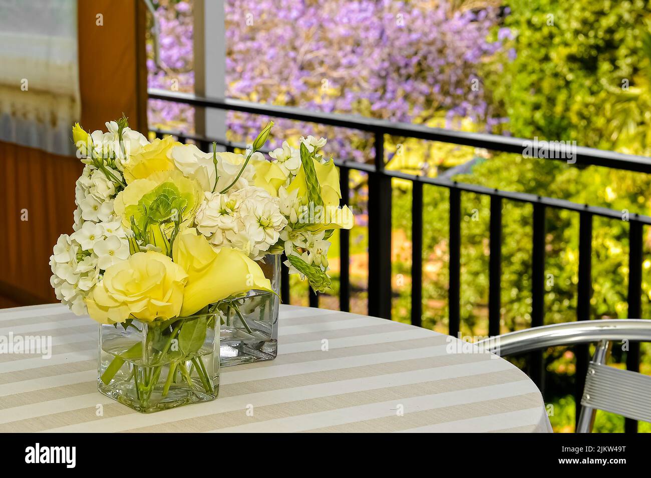 A beautiful glass flower vases on a table next to balcony in a ...