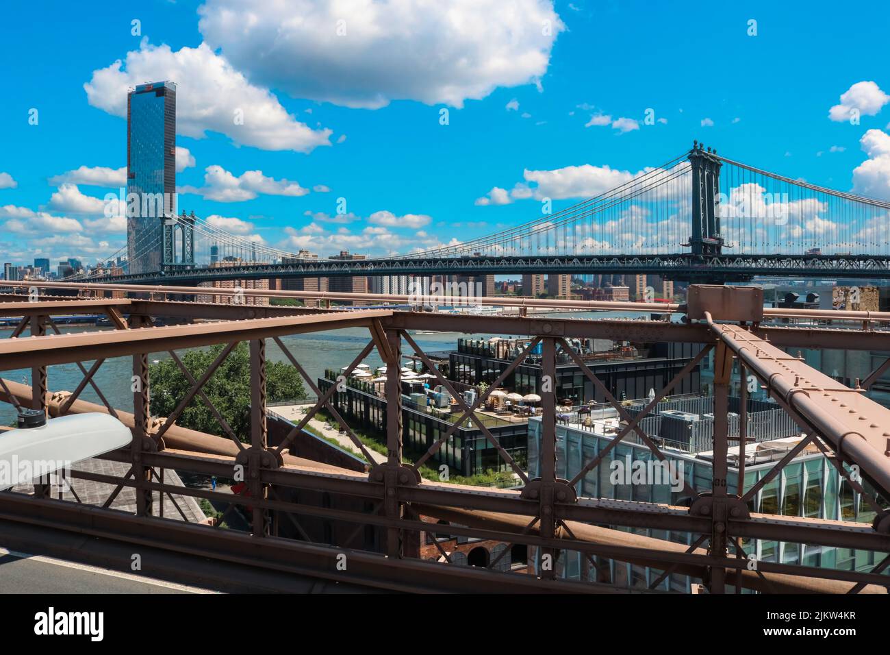 The view of Manhattan Bridge against the blue sky with white clouds ...
