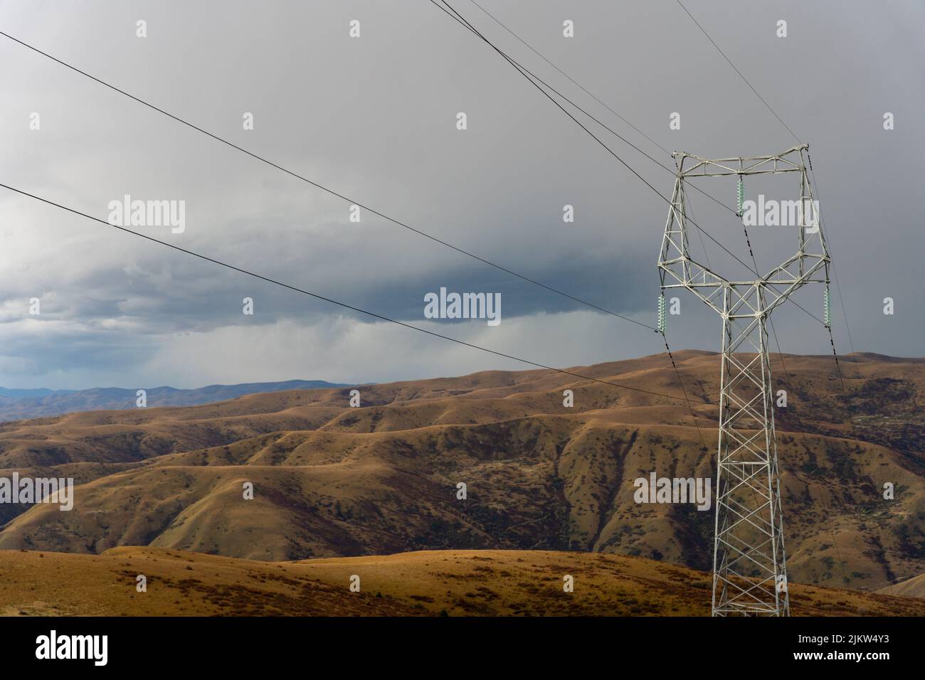 A high electricity transmission pole in a rural area in cloudy sky ...