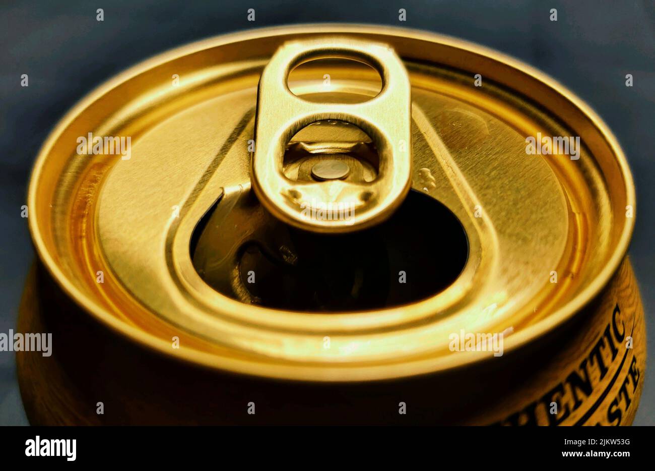 Open top of a golden beer can viewed at a 35 degree angle set at grey ...