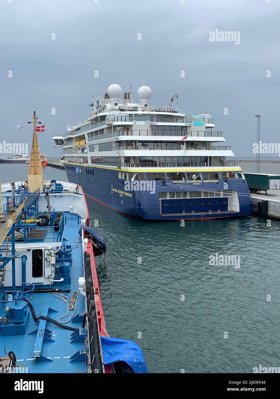 A vertical shot of a bunker vessel riding towards the cruise ship in ...