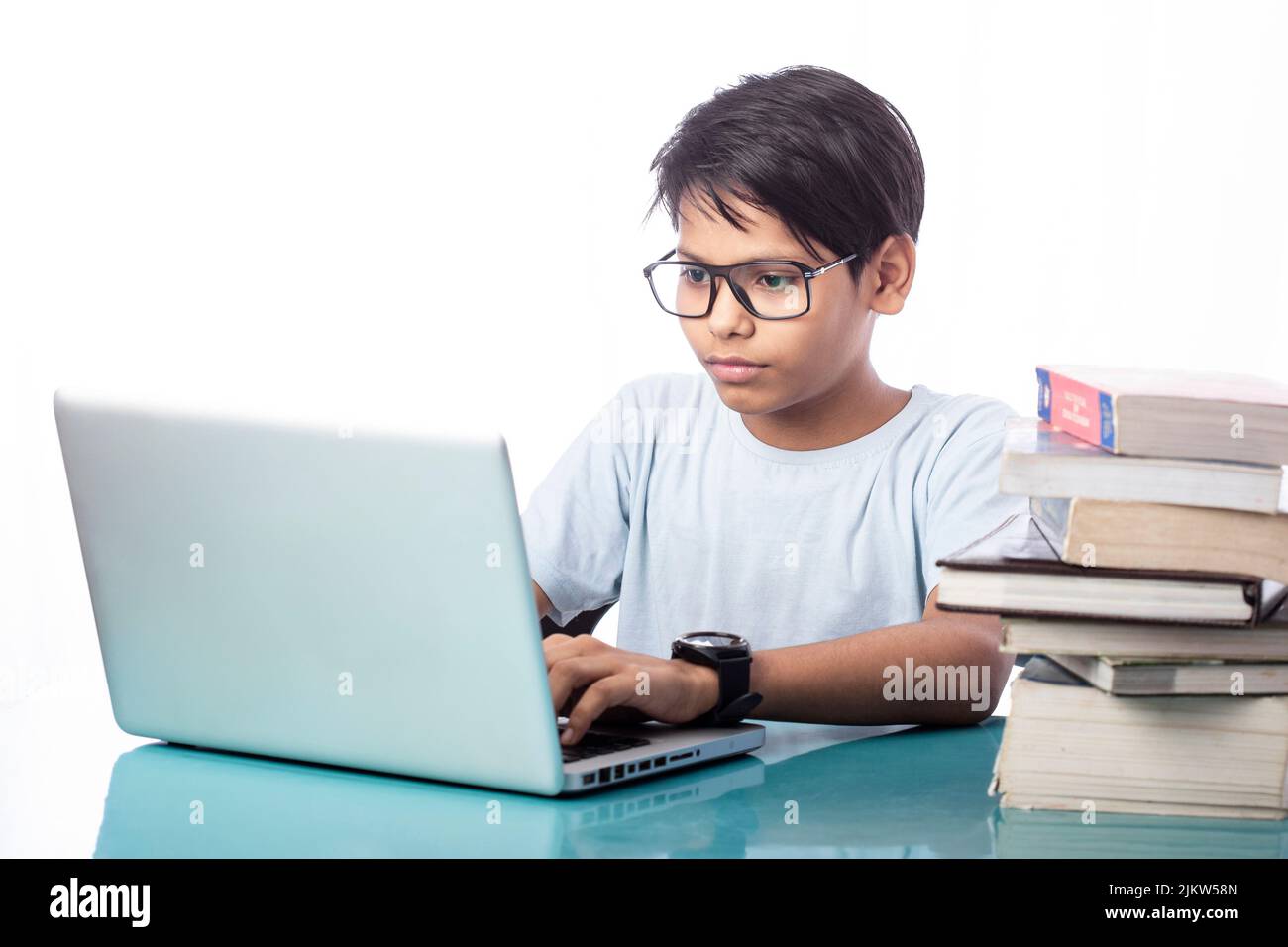 smart child using laptop for online education with some books on desk ...