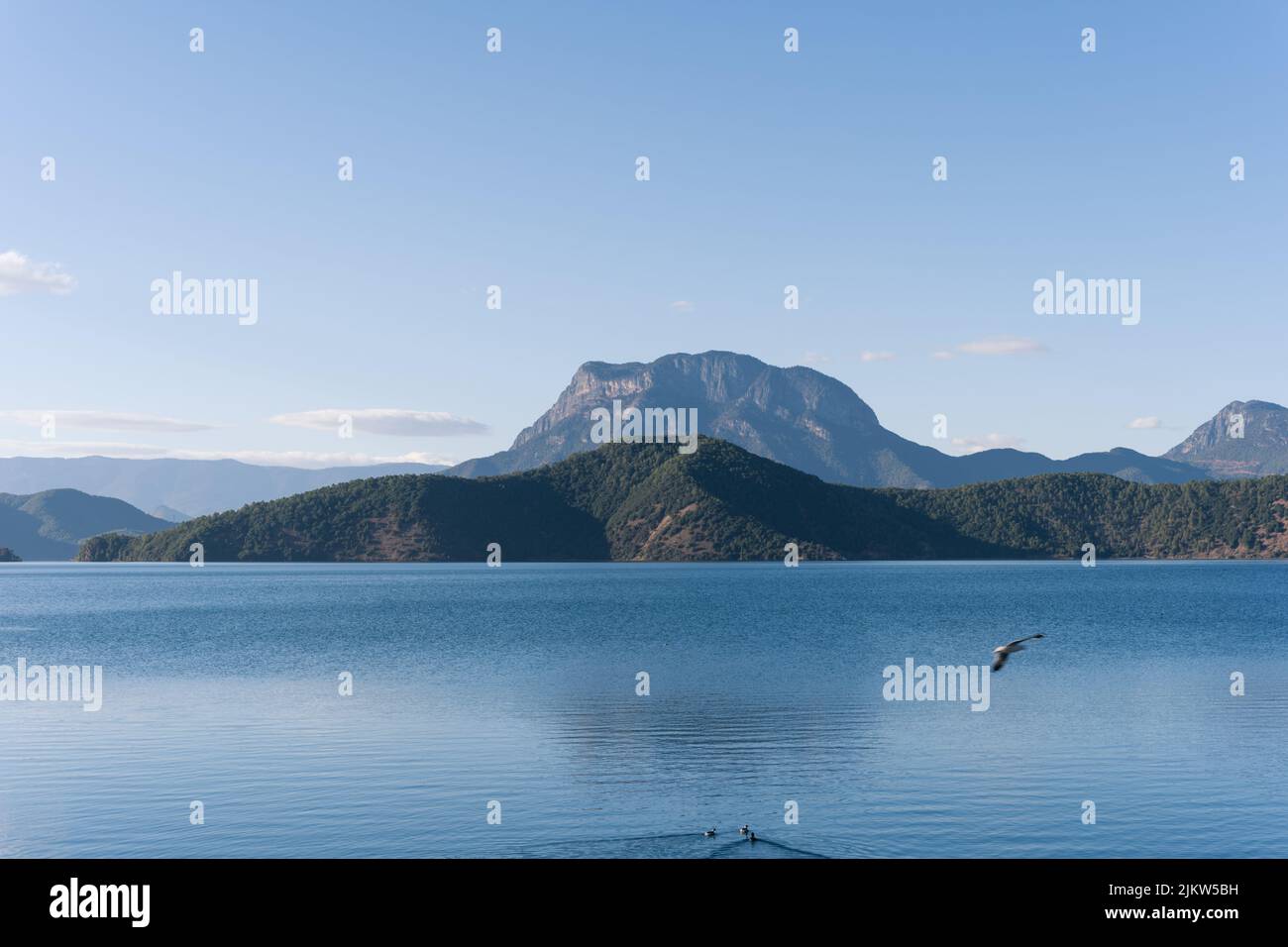 An aerial view of Lugu Lake in China surrounded by rocky mountains in ...