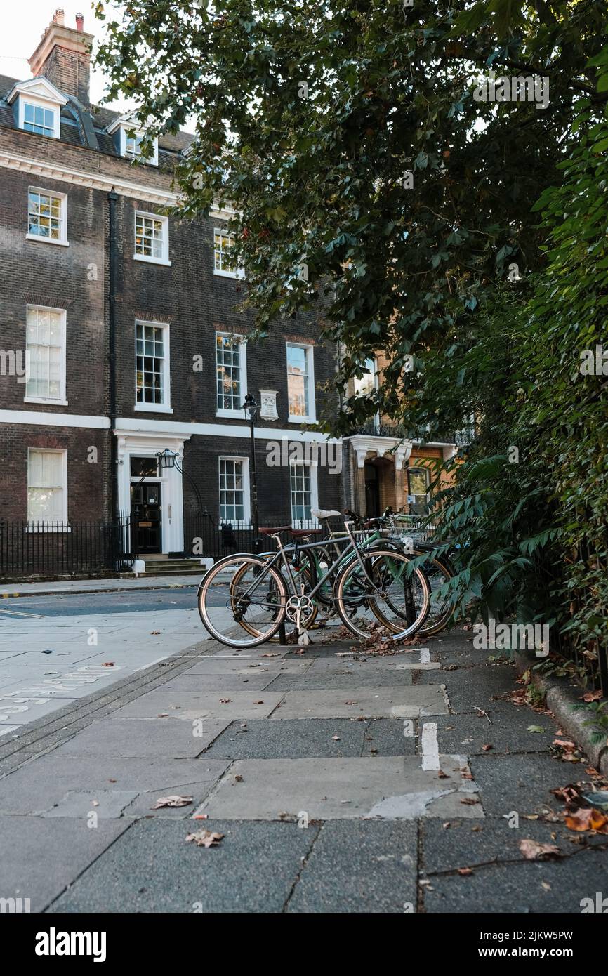 A vertical shot of a bike rack with bicycles near a residential black ...