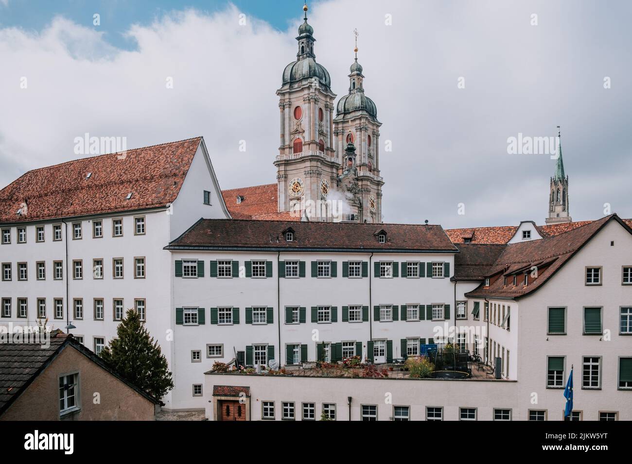 The towers of the saint gall abbey behind buildings Stock Photo - Alamy