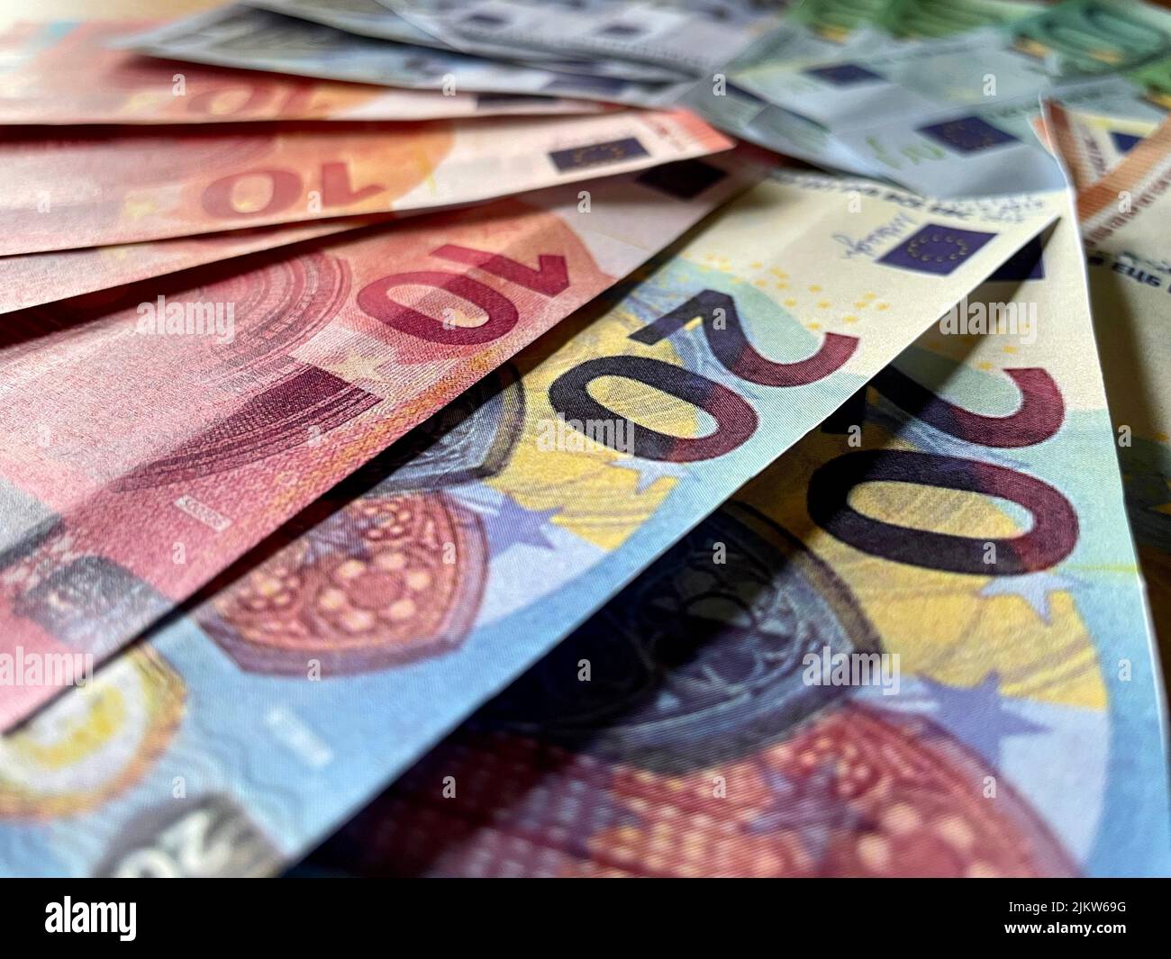 A selective focus shot of twenties and tens of Euros banknote spread on ...