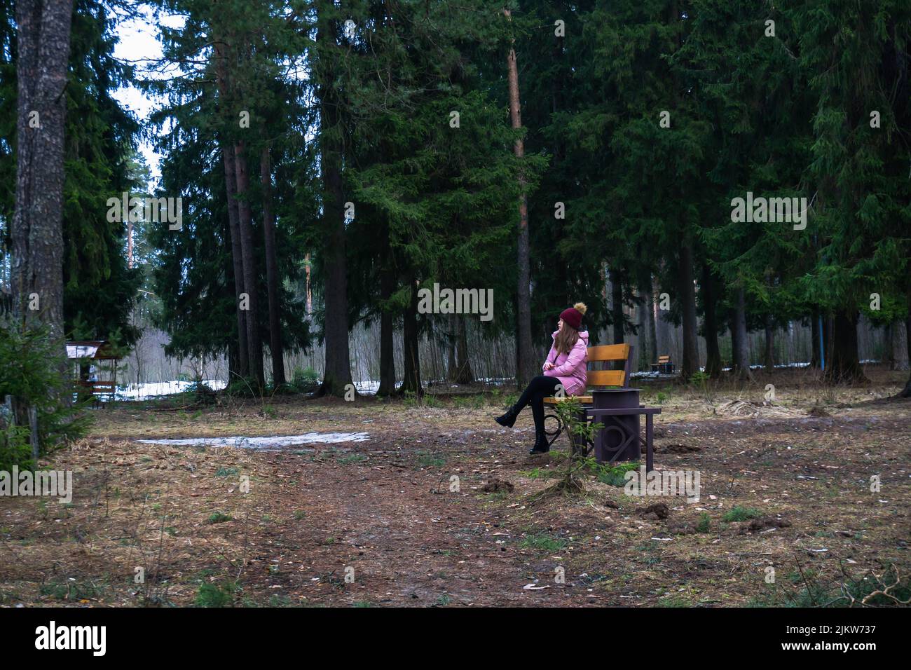 beautiful woman in a forest on a spring afternoon, still quite cold ...