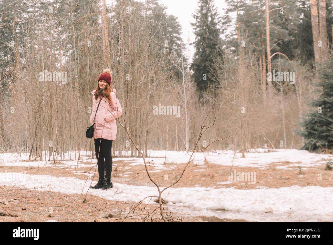 beautiful woman in a forest on a spring afternoon, still quite cold ...