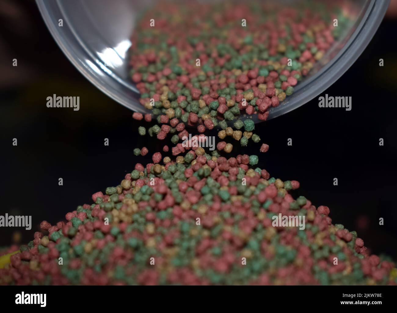 Heap of colored fish food granules on white background Stock Photo - Alamy