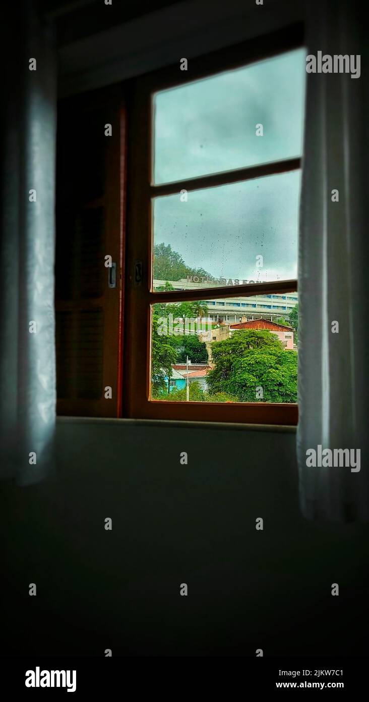 A window in a dark room with a view of a modern houses Stock Photo - Alamy