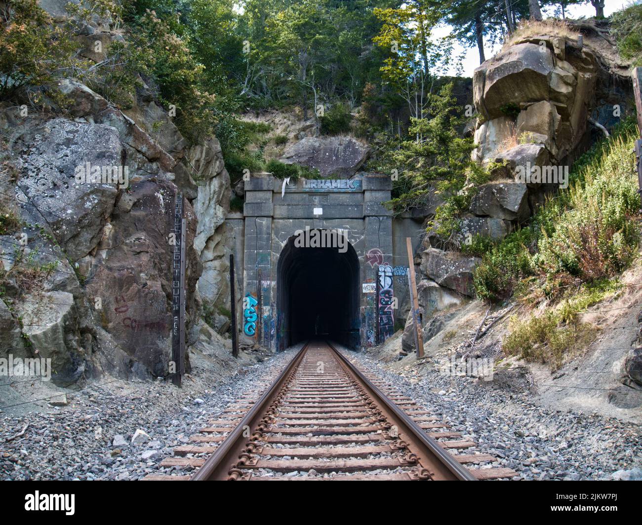 An old and rustic railroad outside a dark tunnel Stock Photo - Alamy