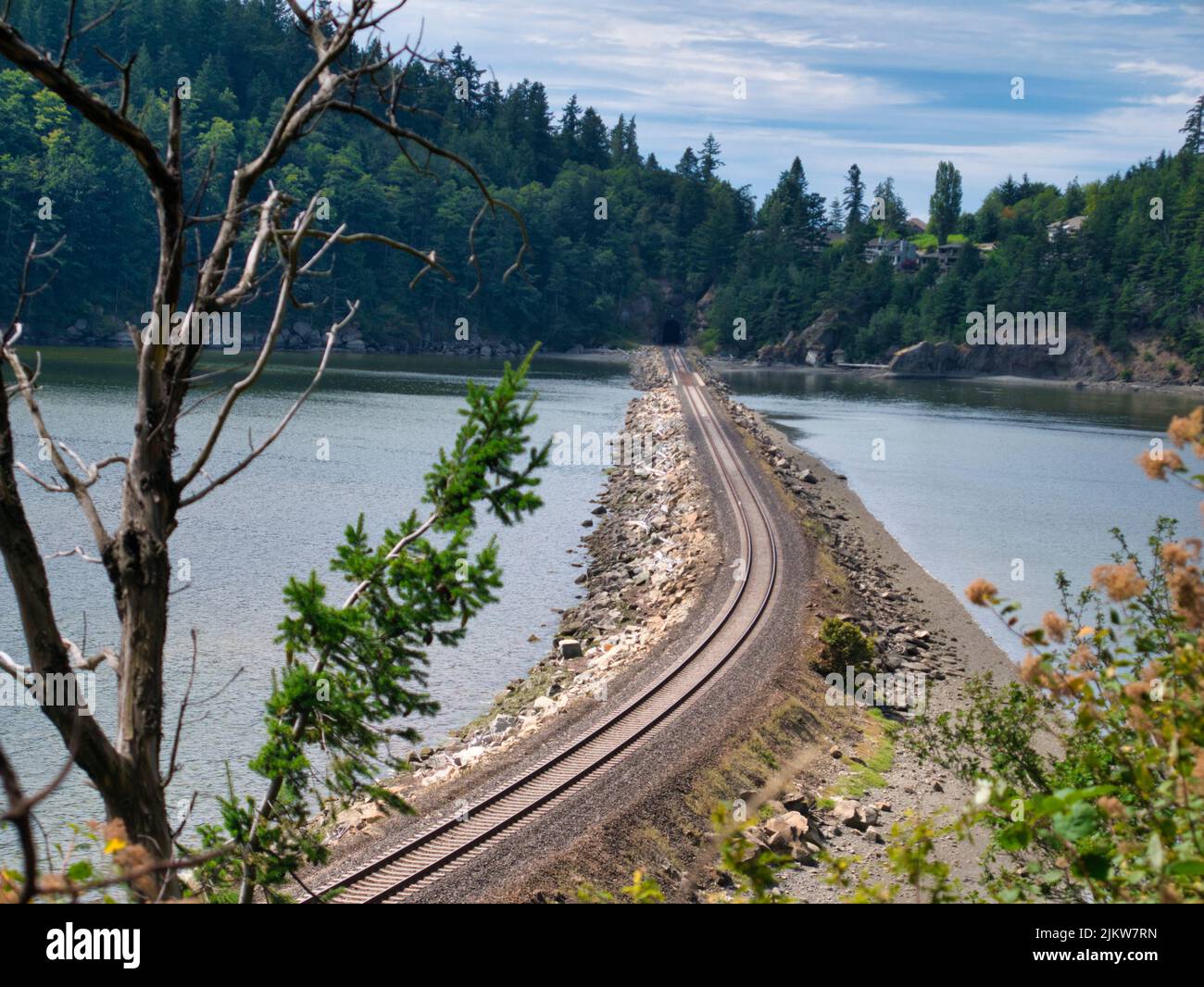 A natural view of a lagoon with a railroad in the middle Stock Photo ...