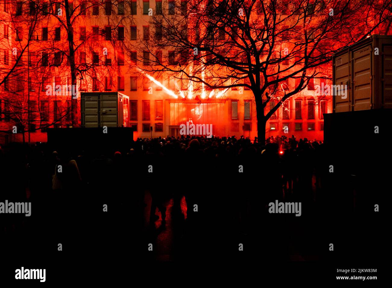 People watching red light art performance Stock Photo - Alamy
