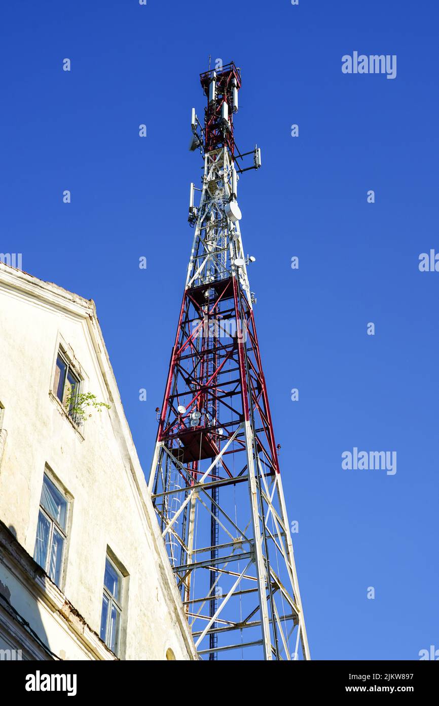 High modern telecommunication tower in city with TV antennas and ...