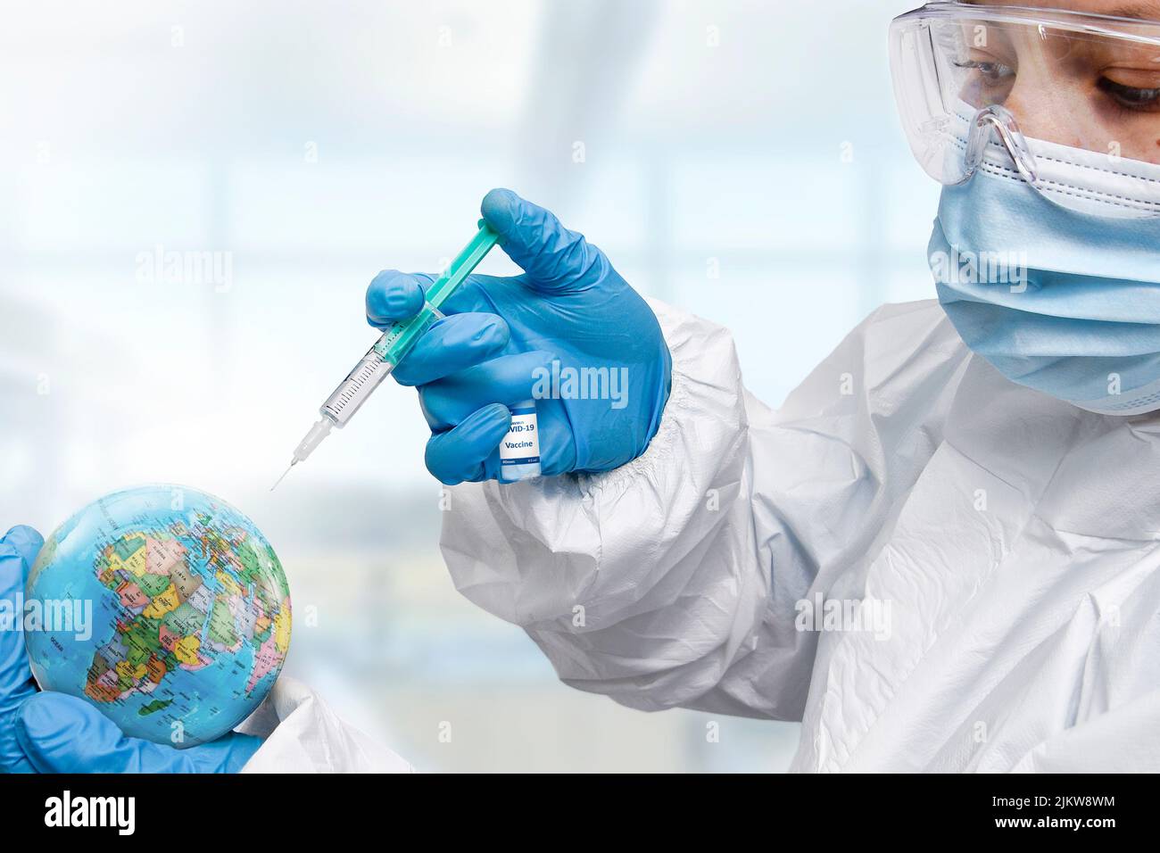 A doctor injecting syringe of Coronavirus vaccine on the planet earth ...